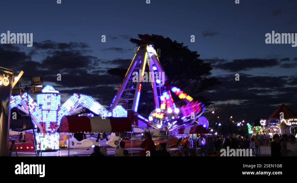 Carnival Rides spinning rotating with colorful neon Lights Crowd dark ...