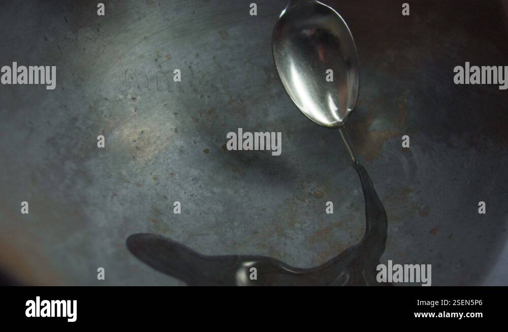 Close-up of chef adds in a cast-iron frying pan olive oil to cook ...
