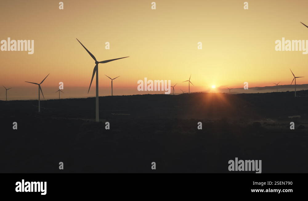 Wind turbines on coast island. Sunbeams. Golden sunset soft light. Wind ...