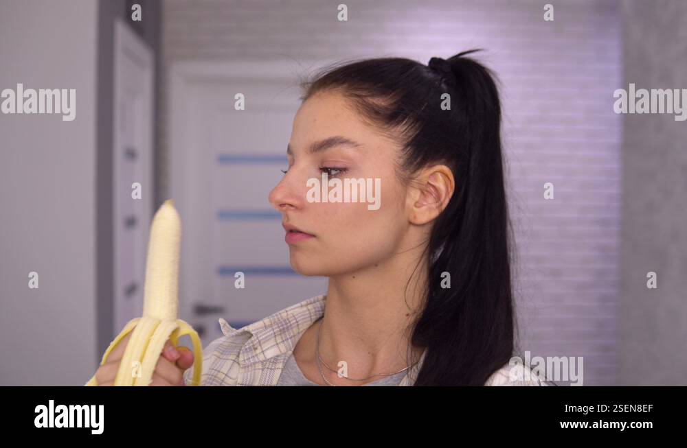 Young woman peeling banana, biting. Eating organic fruit, healthy ...