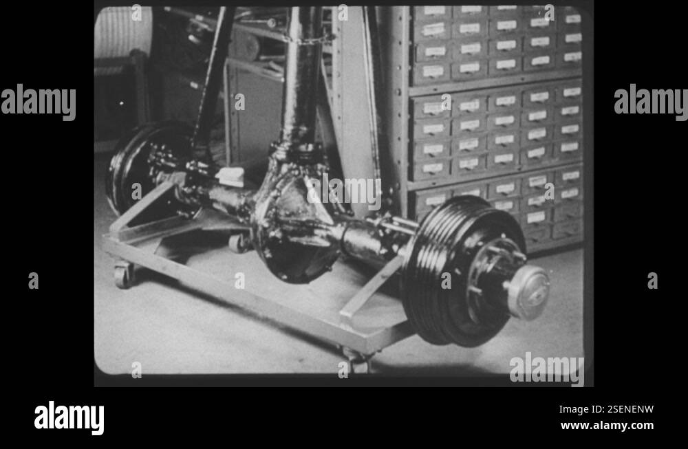 1930s: Bus axle in a stock room. A bus pulls away from a curb. Bus ...