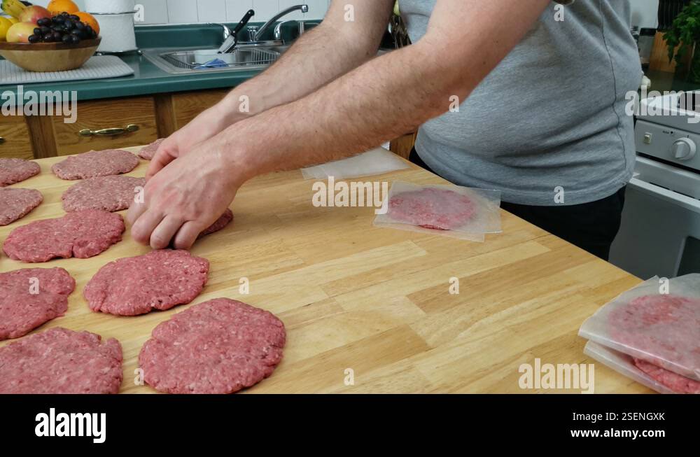 Wrapping in wax paper freshly made or formed burgers from ground beef ...
