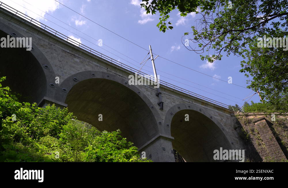 Looking up at Viaduct arches against blue sky with train tracks Stock ...