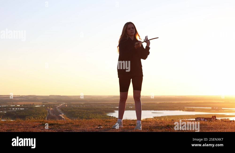 Swords training - young woman with long hair waving with a sword in ...