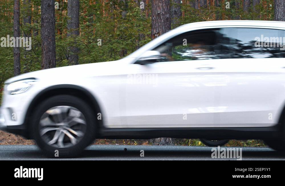 Motor riding - a women in helmet riding on a road in the woods with ...