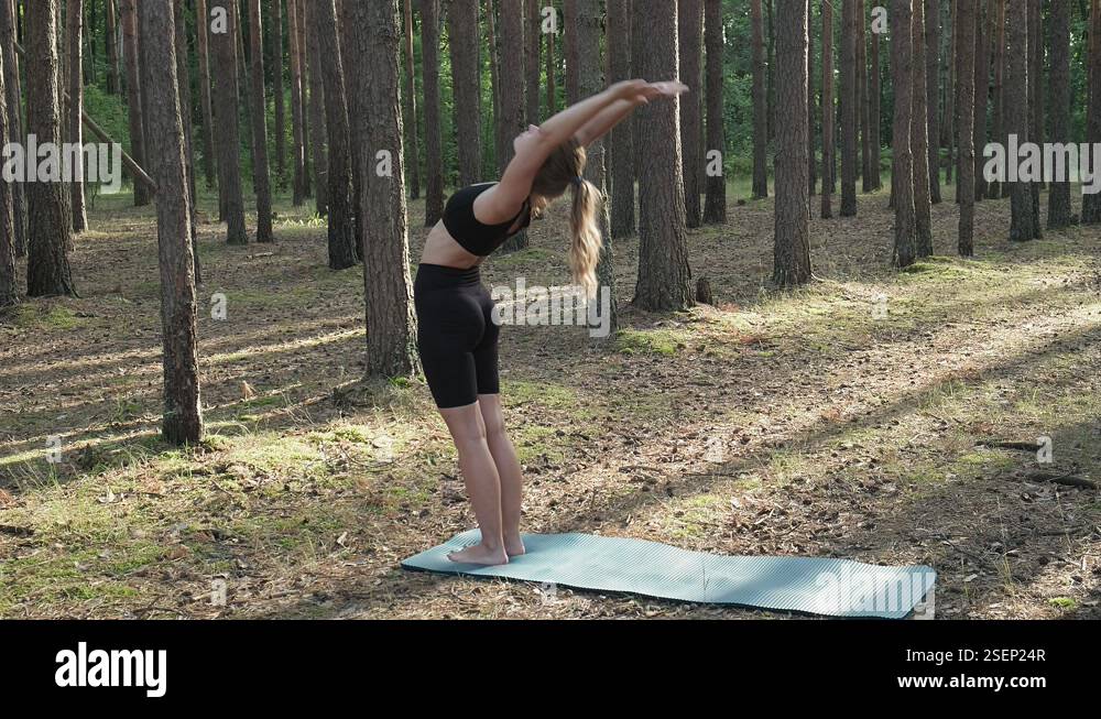 flexible fit female practices yoga, performs surya namaskar at sunny ...