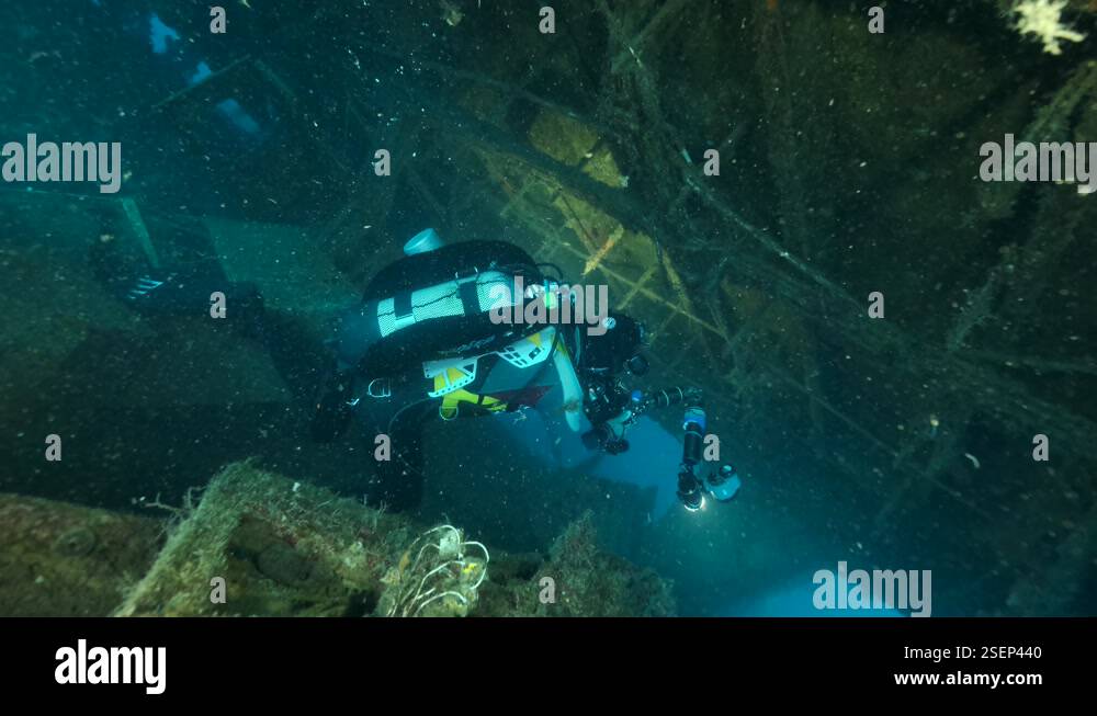 Scuba diver photographer swims and shots inside of the shipwreck ...