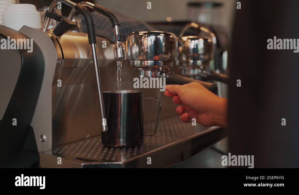 boiling hot water pouring from automatic boiler of espresso coffee ...