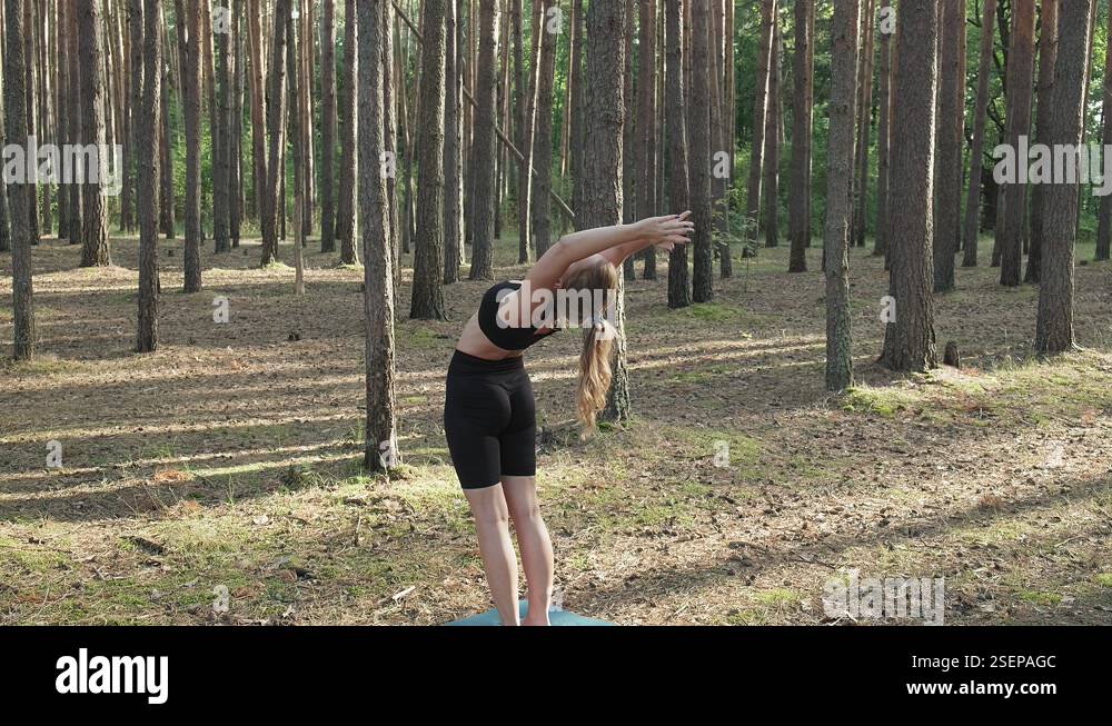 flexible fit lady practices yoga, performs surya namaskar at sunny pine ...