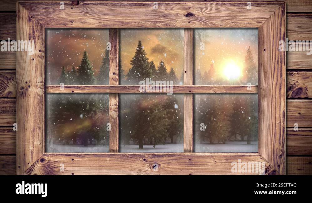 Wooden window frame against snow falling over multiple trees on winter ...
