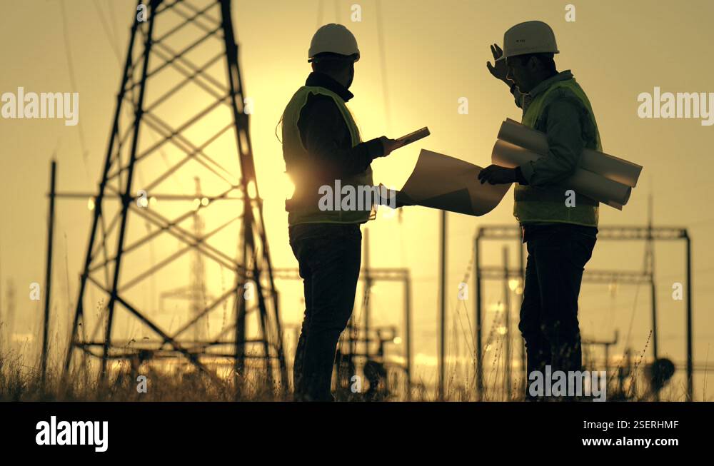 Silhouette of engineers looks at the construction of high-voltage power. Teams Stock Video ...