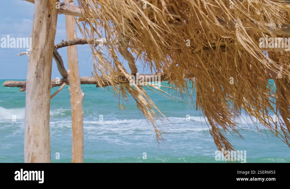 Thatched Hut On Tropical Beach With Blue Sea In The Background On A ...