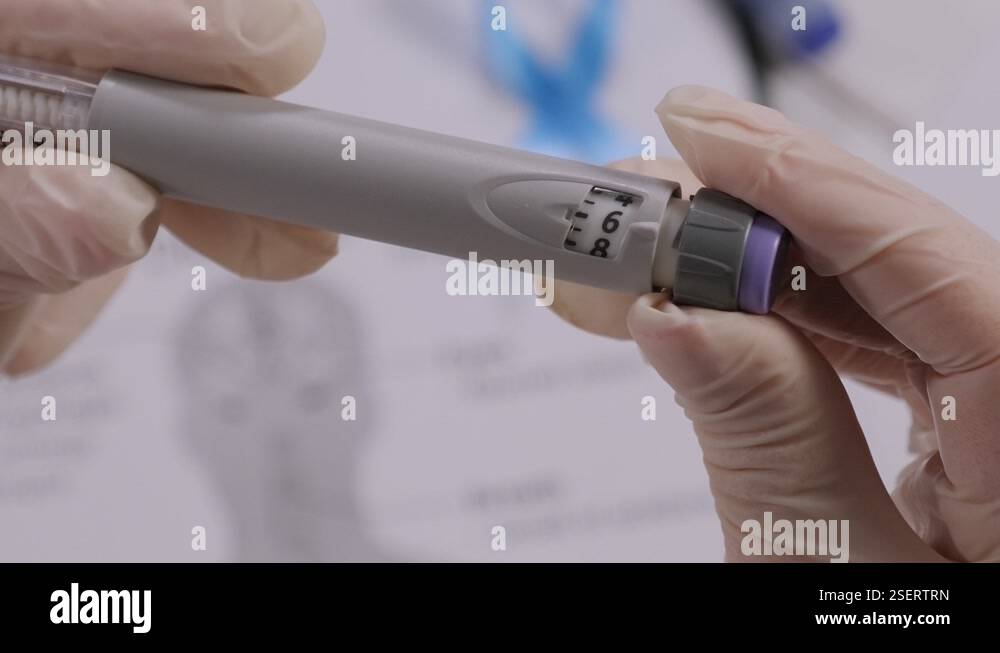 A close-up of a doctor in medical gloves dial the right dose on an ...