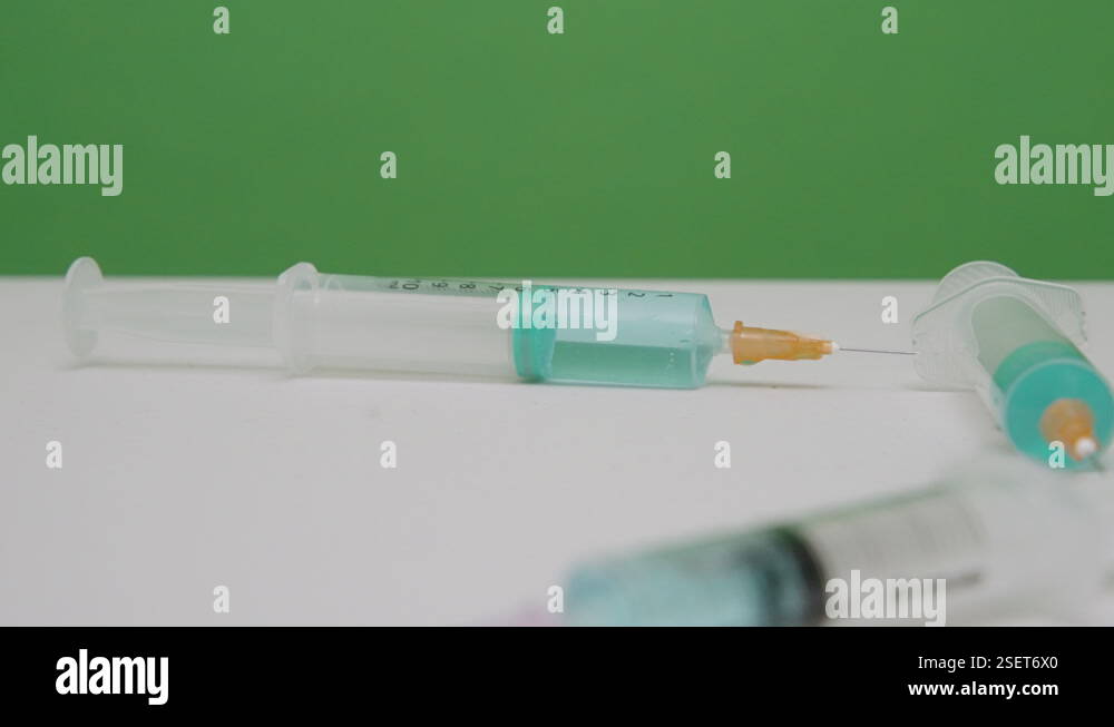 Multiple Medical needle shots on a white table with a green screen in ...