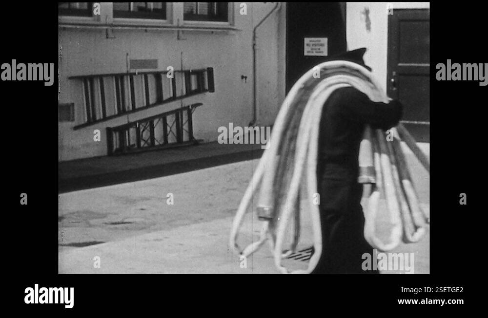 1940s: Firefighter carries firehose over shoulder. Firefighter lays out ...
