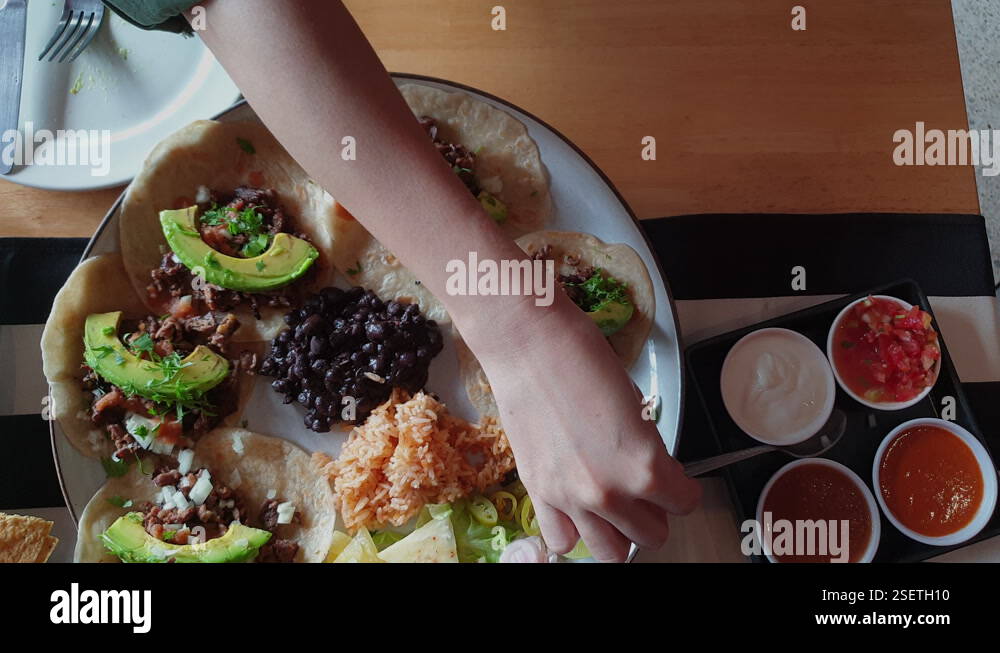 Adding salsa on soft shell sirloin beef steak taco with avocado ...