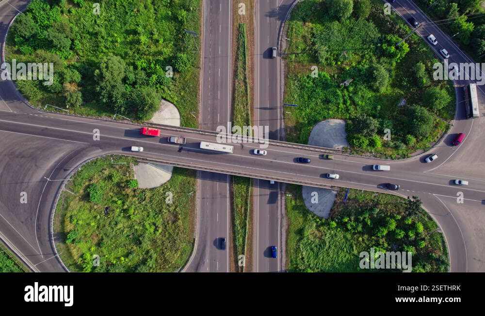 Traffic driving over roundabout with highway road underneath Stock ...