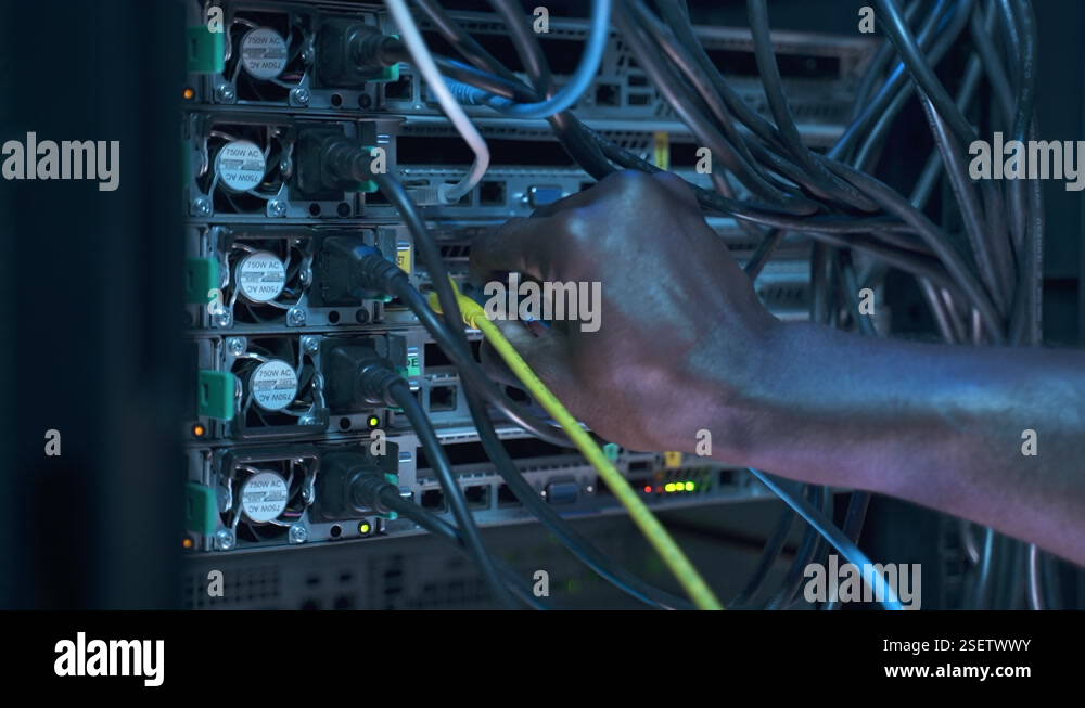 Closeup of man engineer working with cables and networks during dark ...