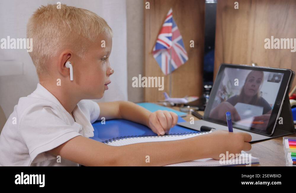 A boy in wireless headphones communicates in a video conference with a ...