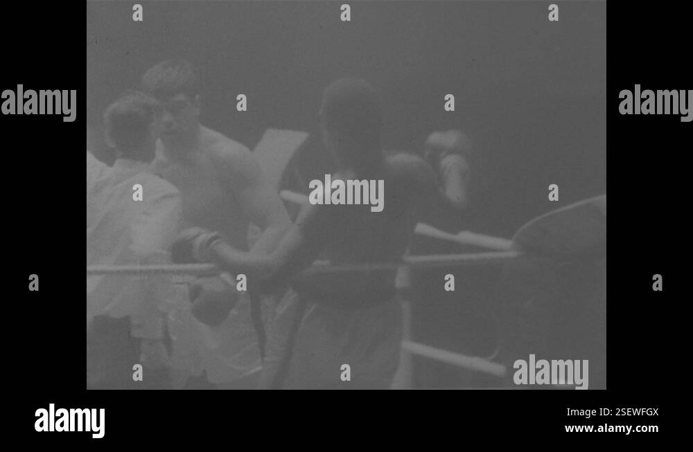 1960s: Boxing match. Men punch. Referee separates men and gestures ...