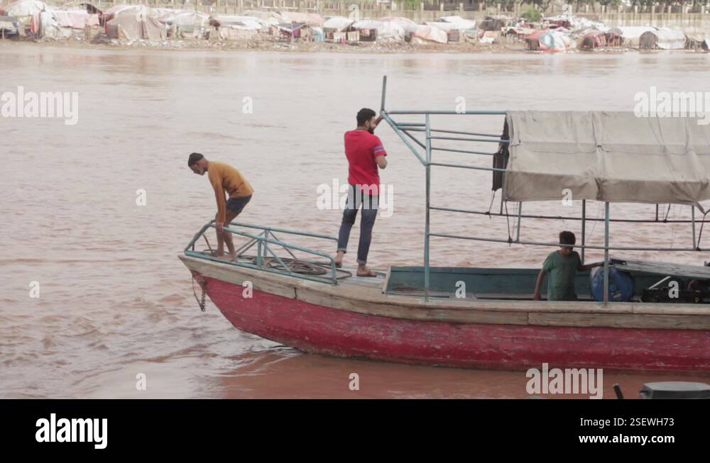 Villagers Riding On A Boat Near Slums On The River Ravi, Pakistan Stock ...