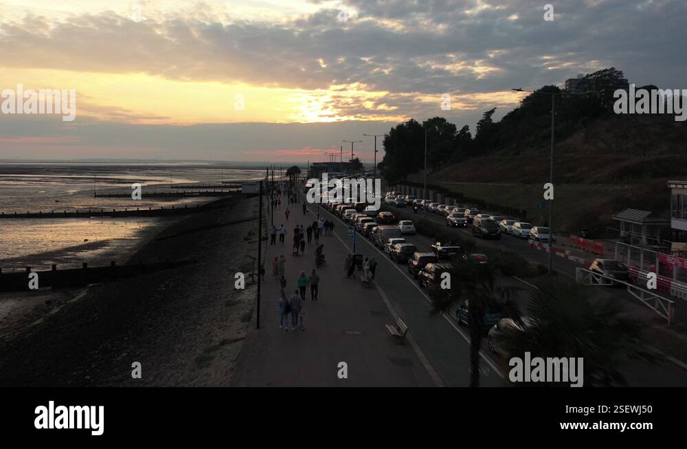 Queue of slowly moving cars and people walking on pathway along Stock ...