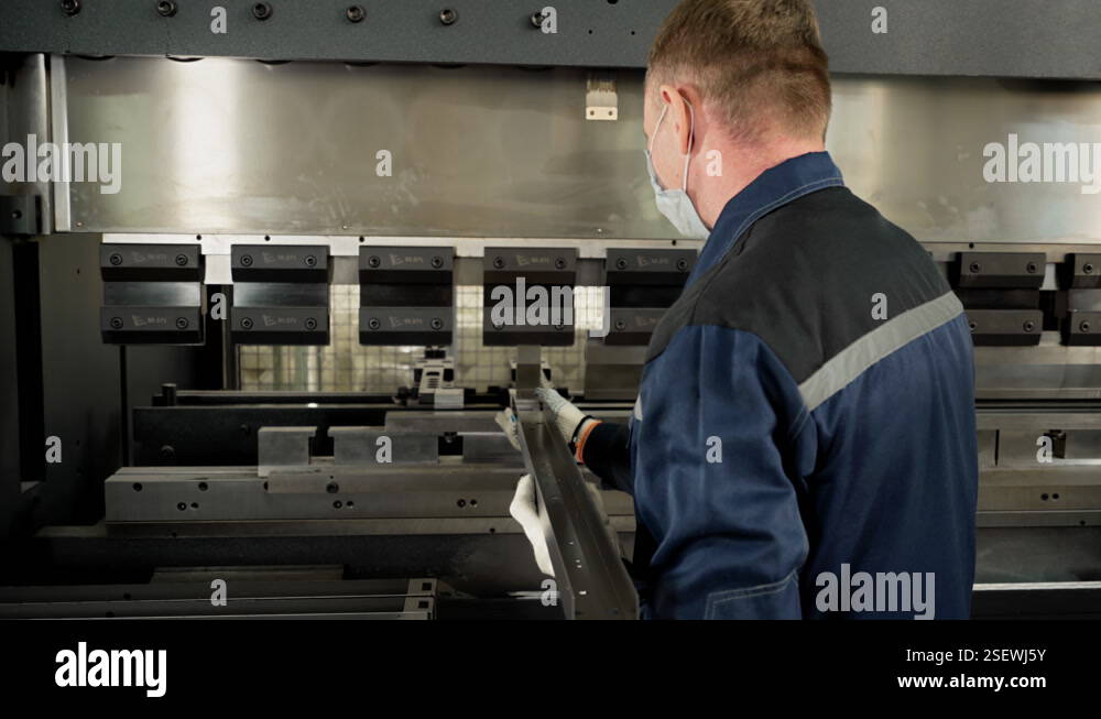 Worker Performs Operations With Metal Sheets At Assembly Line On Plant ...