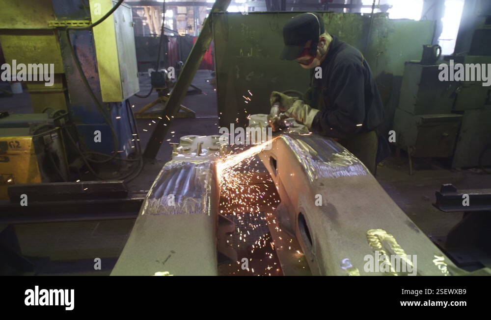 Factory Worker Is Grinding A Metal Construction With A Circular Saw ...
