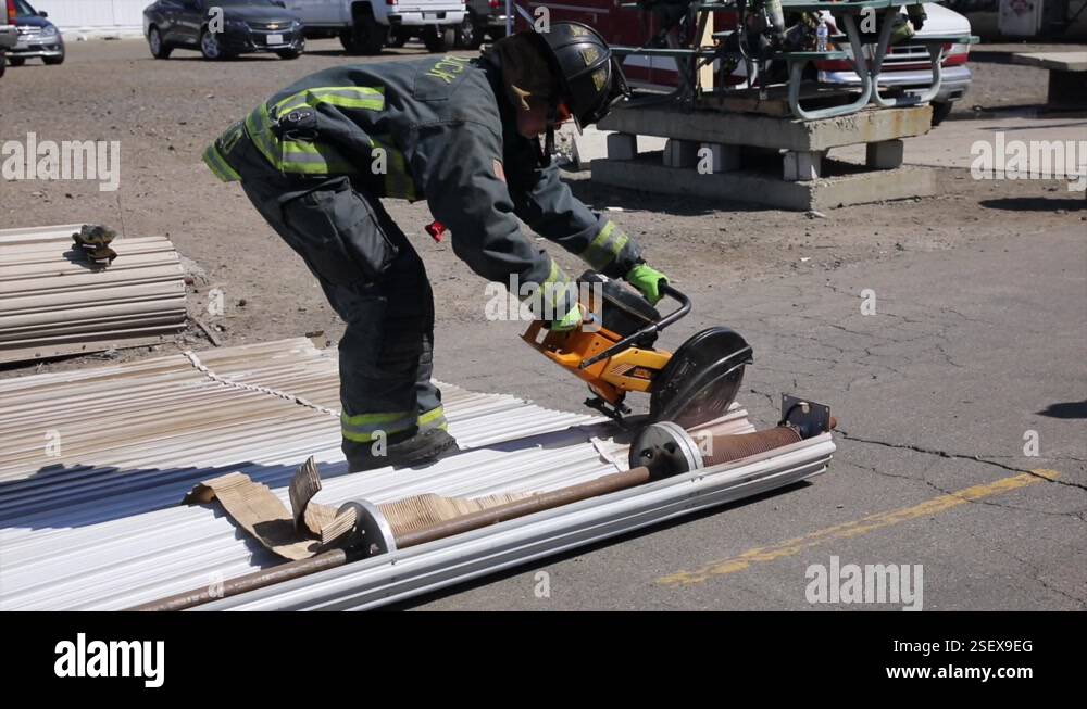 slow motion 60 fps firefighters sawing through metal door with chainsaw ...