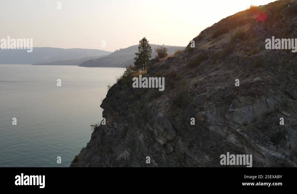 Aerial footage of rattlesnake point at kalamalka lake passing cliffs in ...