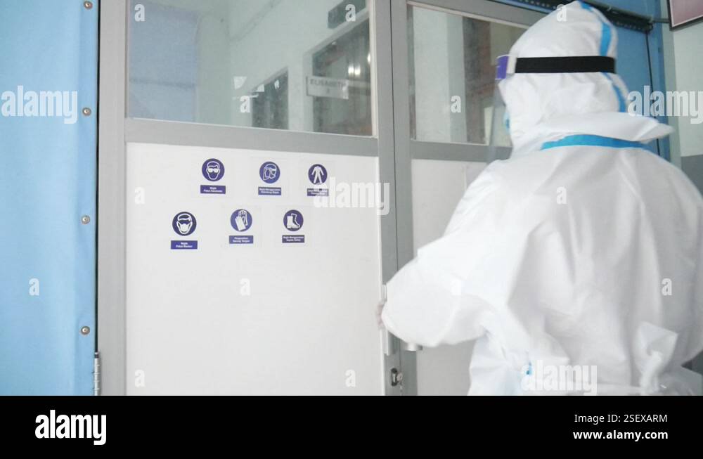 A person wearing full personal protective equipment enters the ...