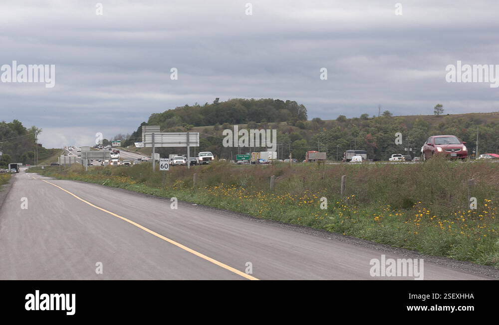 Side view low angle of car and truck traffic speeding by fast on ...