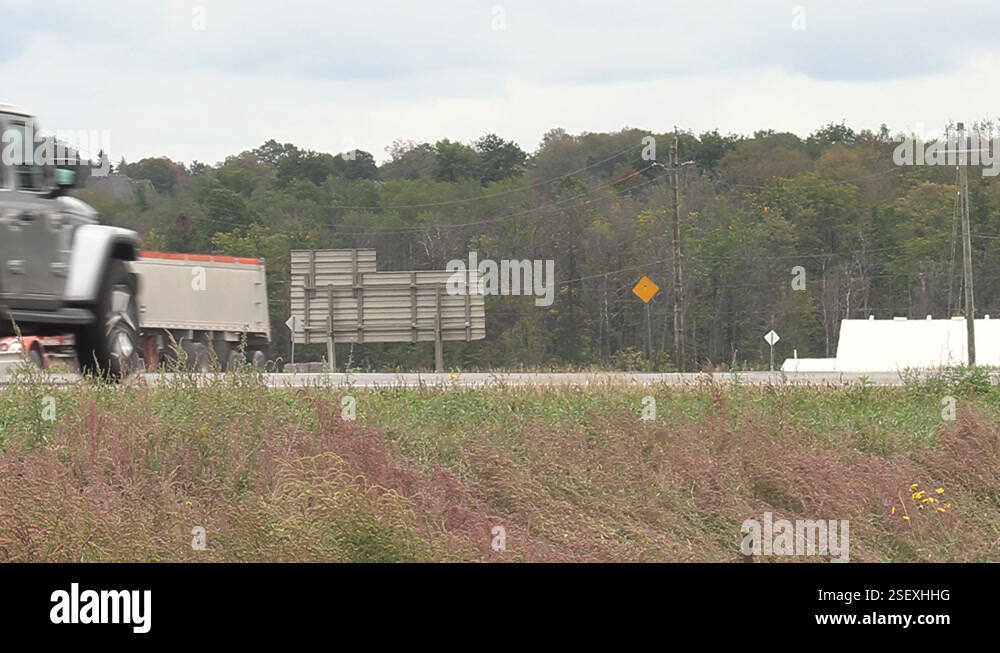 Side view low angle of car and truck traffic speeding by fast on ...