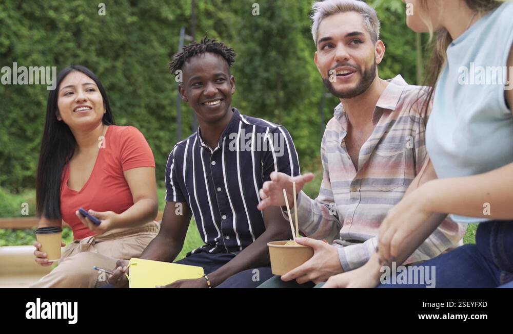 Diverse people having fun eating take away food outdoor in the city ...