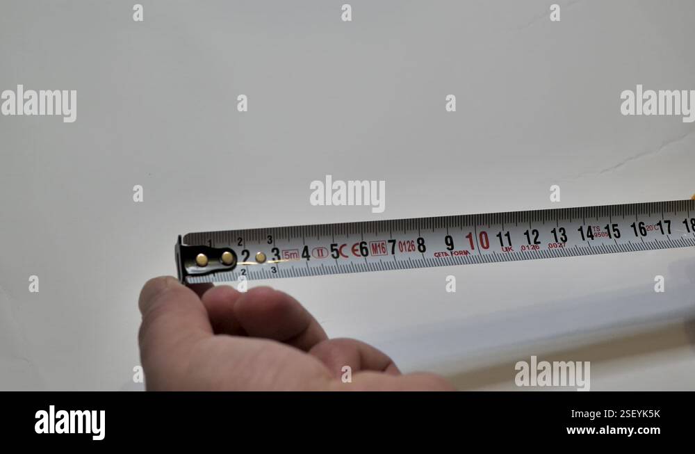 Tape measure. Hands pull the measuring yellow tape out. Roll of ...