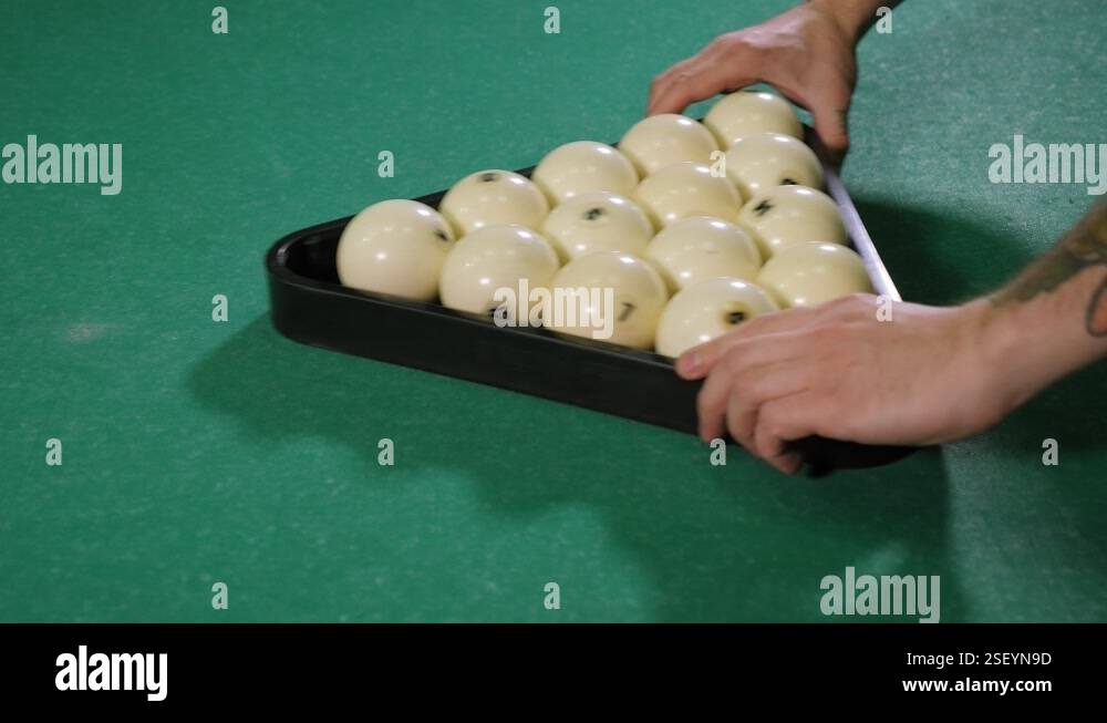 Triangle of billiard balls. A man getting ready to start a game of ...
