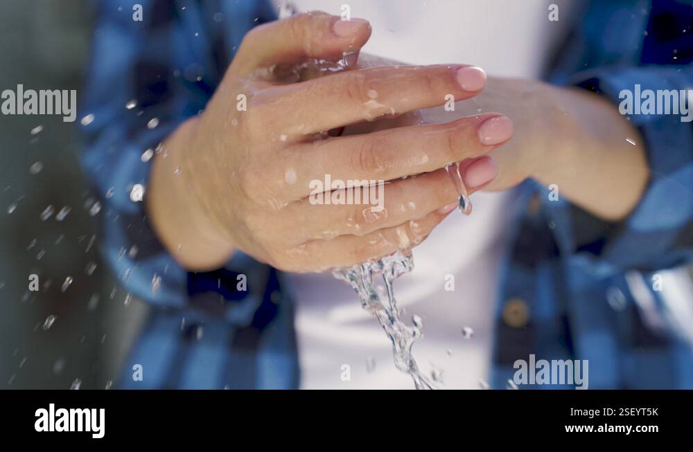 Wash hands under stream of clear clean water, splashes splash and spill ...