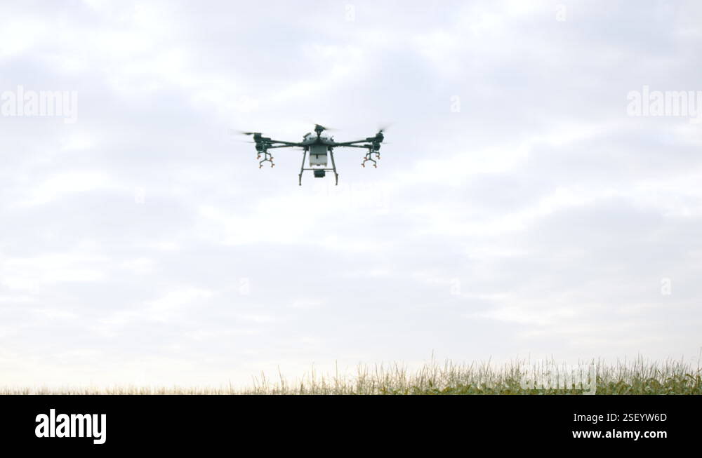 Huge intelligent agriculture drone with spray nozzles flying against ...