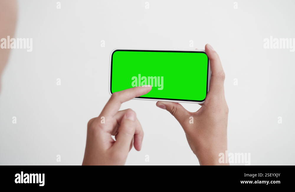 Young Person Look and Tapping Touch Screen Phone with Green Chroma Key ...