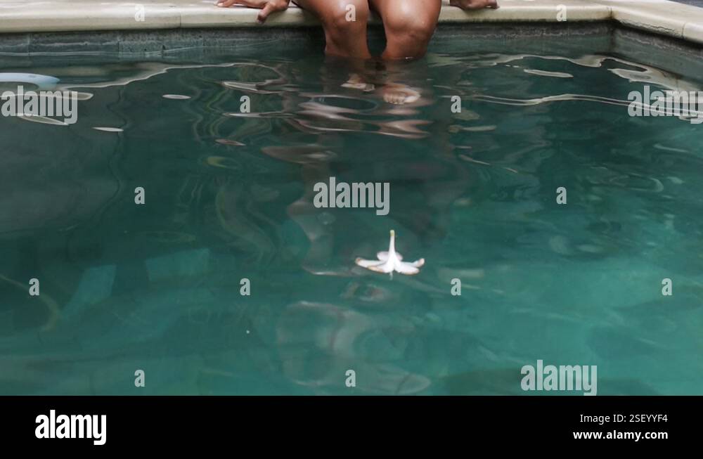 Asian fitness bikini model sitting on pool side at a private villa ...