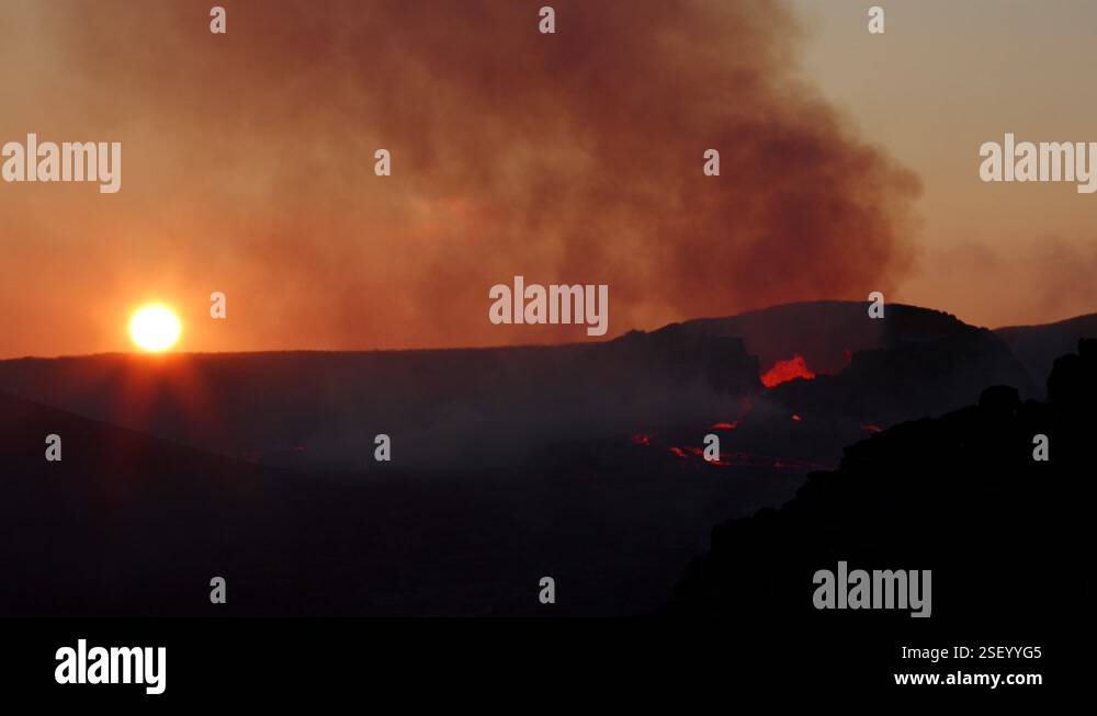 Fagradallsfjall volcano eruption from a distance, while sun is setting ...