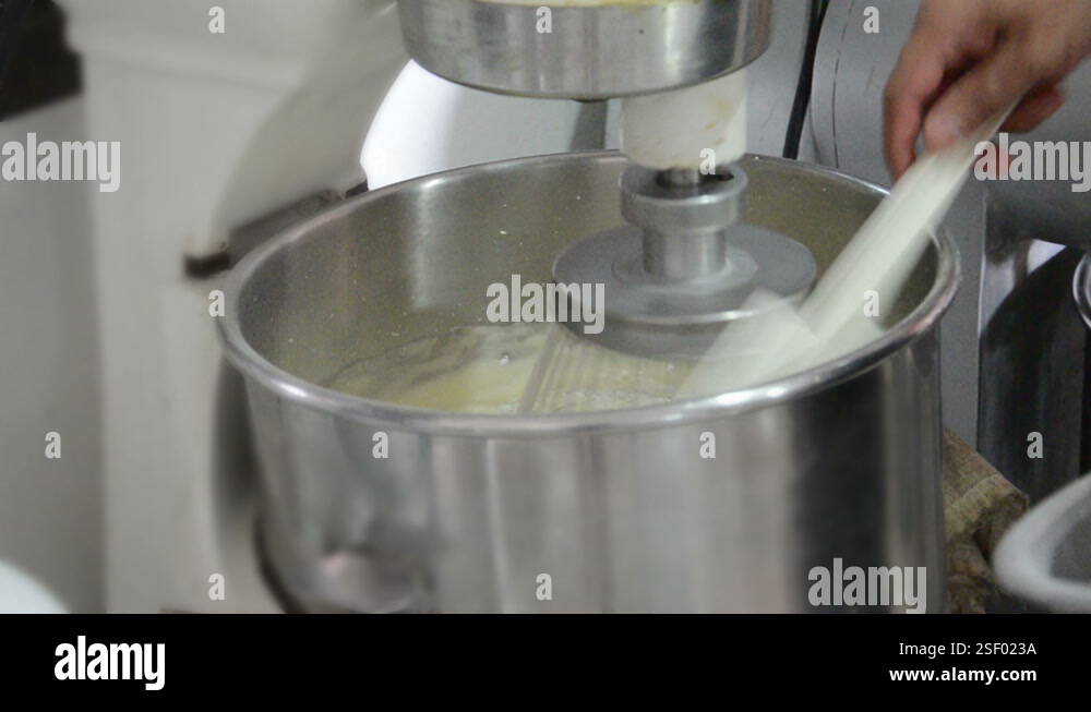 chef using machine to kneading egg and sugar for making dessert , with ...