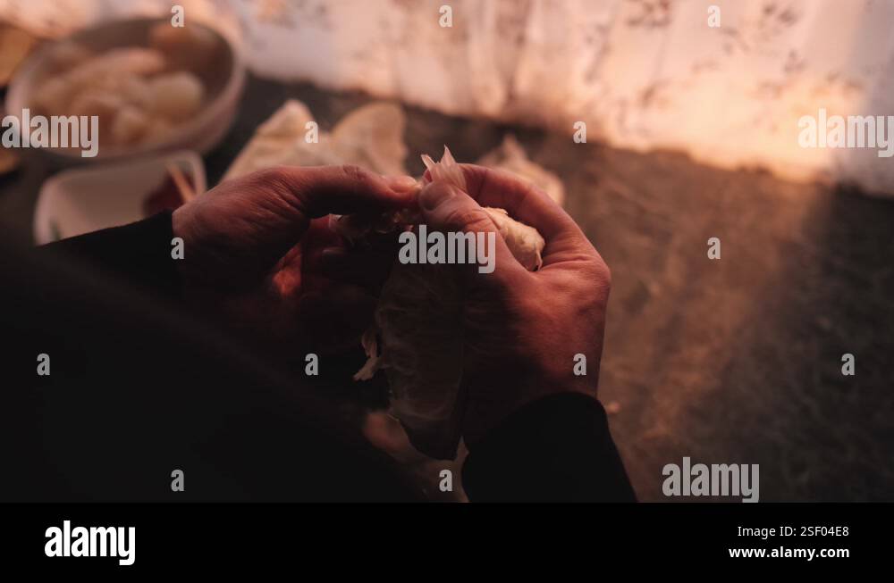A man cleans a piece of pomelo with his hands in the kitchen Stock ...