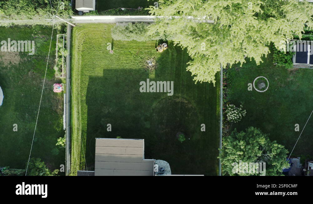 Aerial drone top view of lawn tractor mowing lawn from above on ...