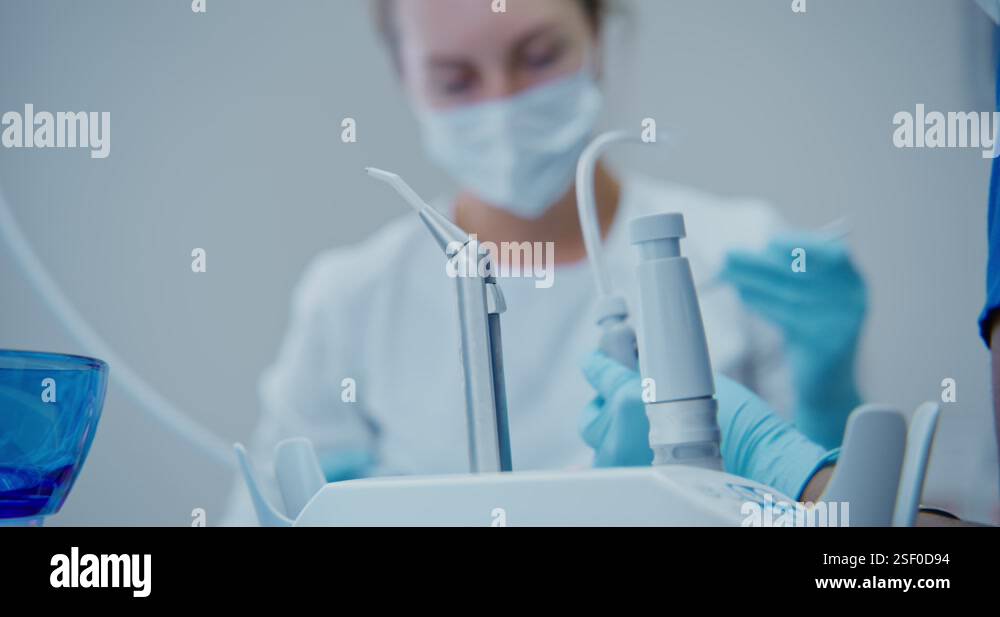 A nurse takes saliva ejector and inserts it into the mouth of a patient ...