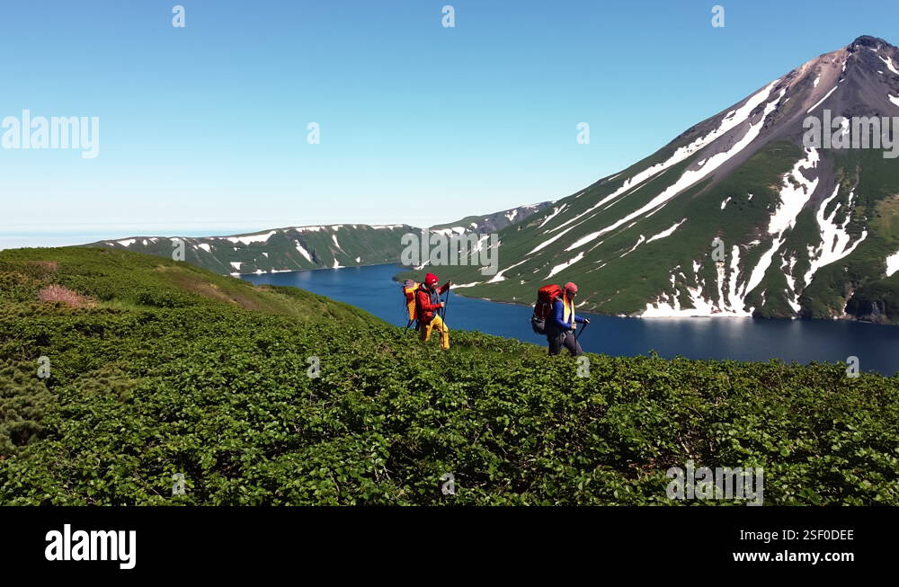 Couple tourists walking on krenitsyn volcano on the Kuril islands ...