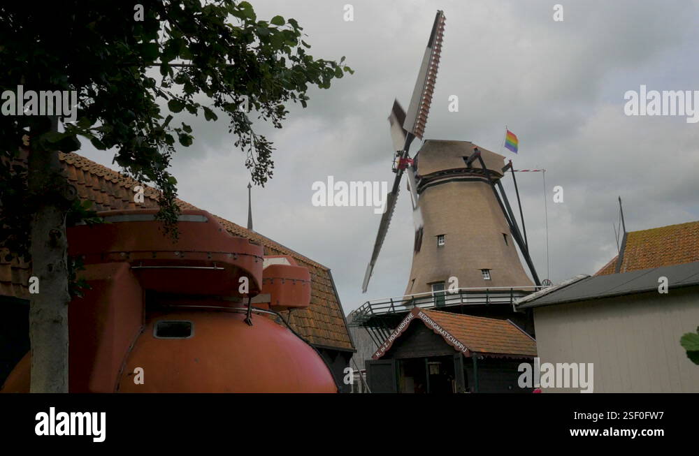 Old Dutch windmill spinning in the wind. On the back of the mill we see ...