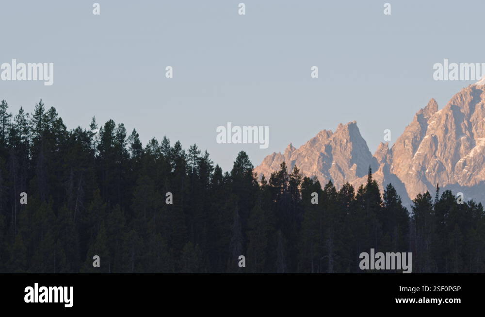 Zoomed panning view looking at the Grand Teton mountains peaking over ...