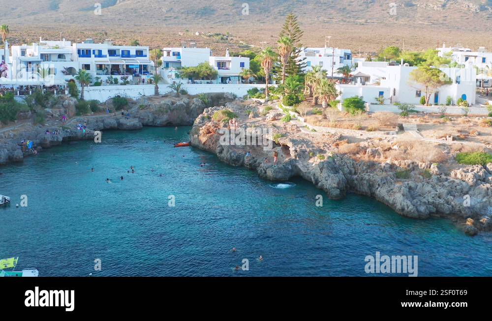 Side view of intrepid people jumping from the cliff in Avlemonas ...