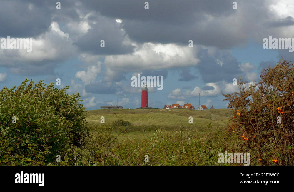 Time lapse through bushes in the foreground. In the distance we see a ...
